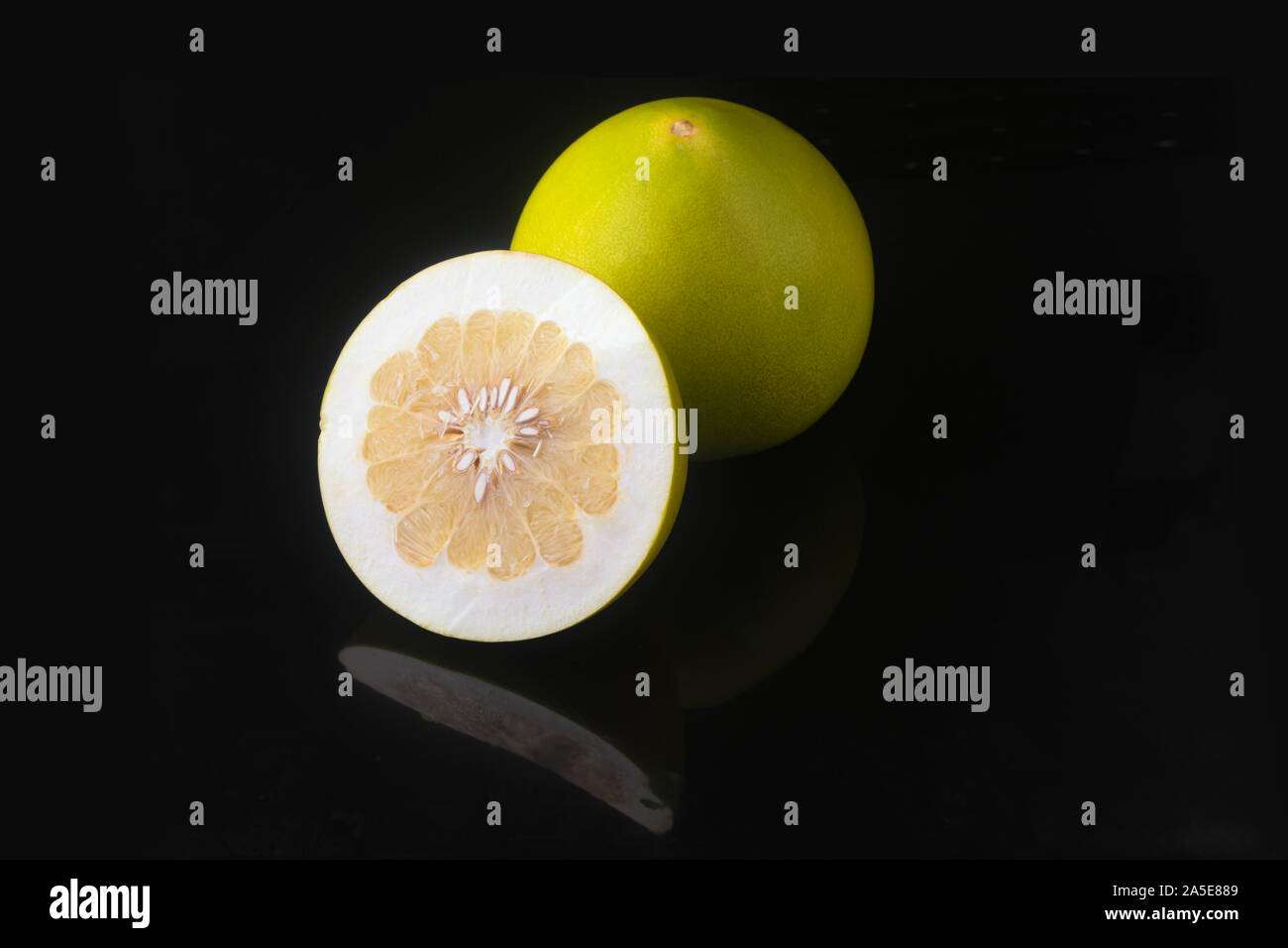 One pomelo and half sliced pomelo fruit on black background with ...