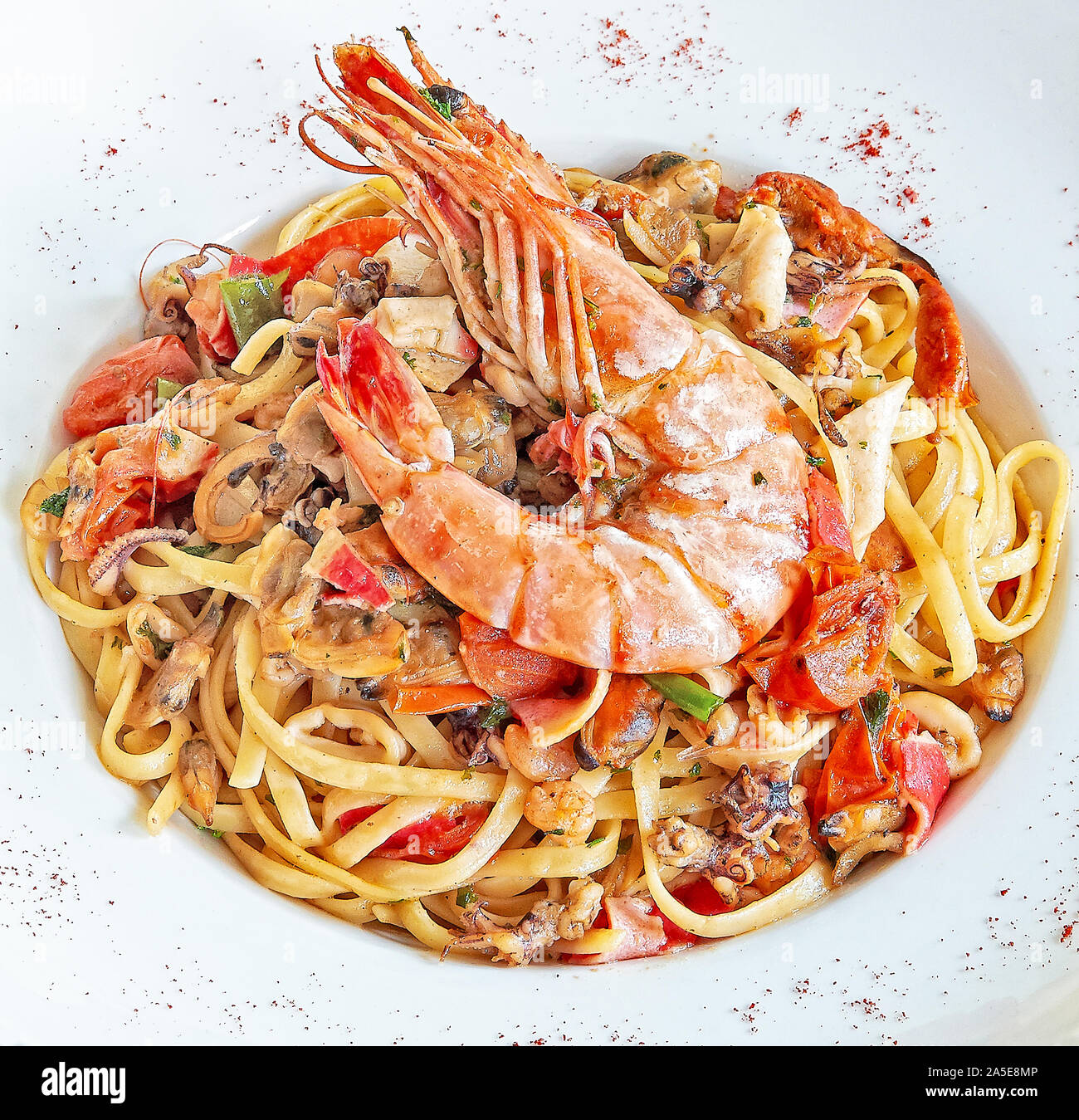 White plate with linguini and shrimp on textured wooden table Stock ...
