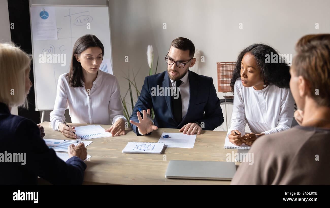 Focused businessman leader explaining corporate strategy during team ...