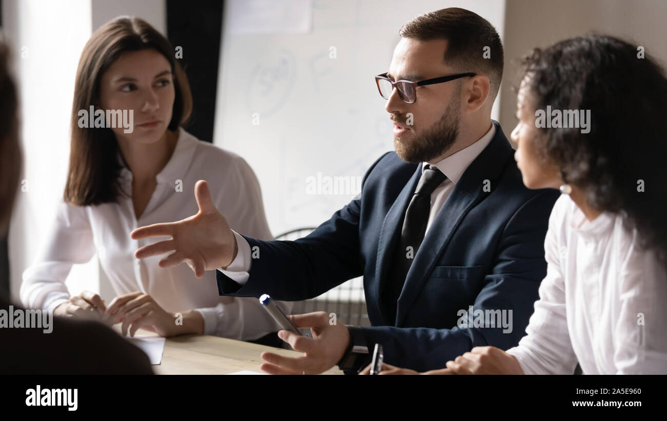 Serious successful businessman ceo teaching workers team at corporate ...