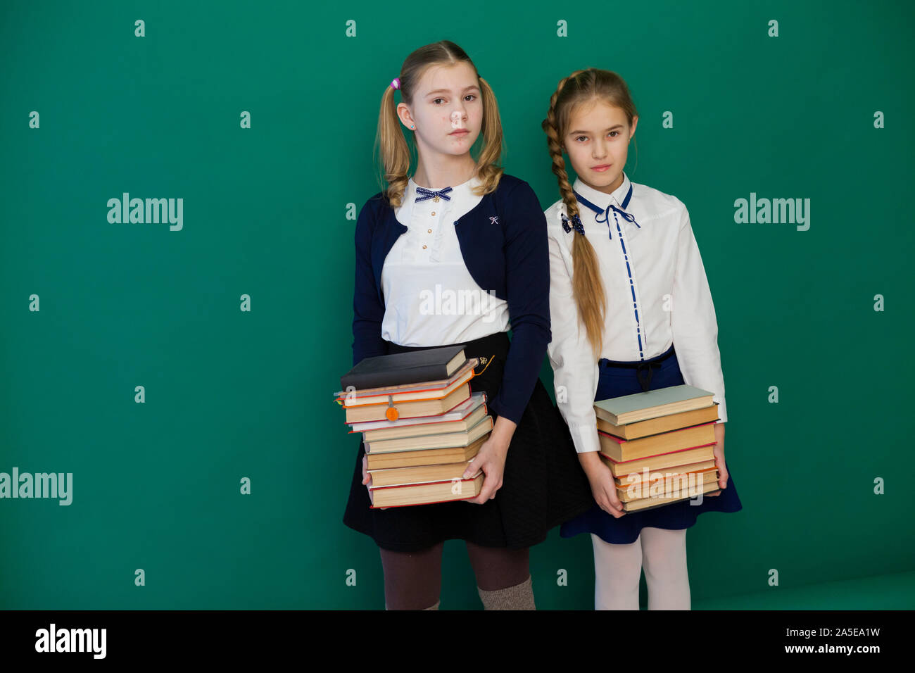 two girls with books in class at the board at school Stock Photo - Alamy
