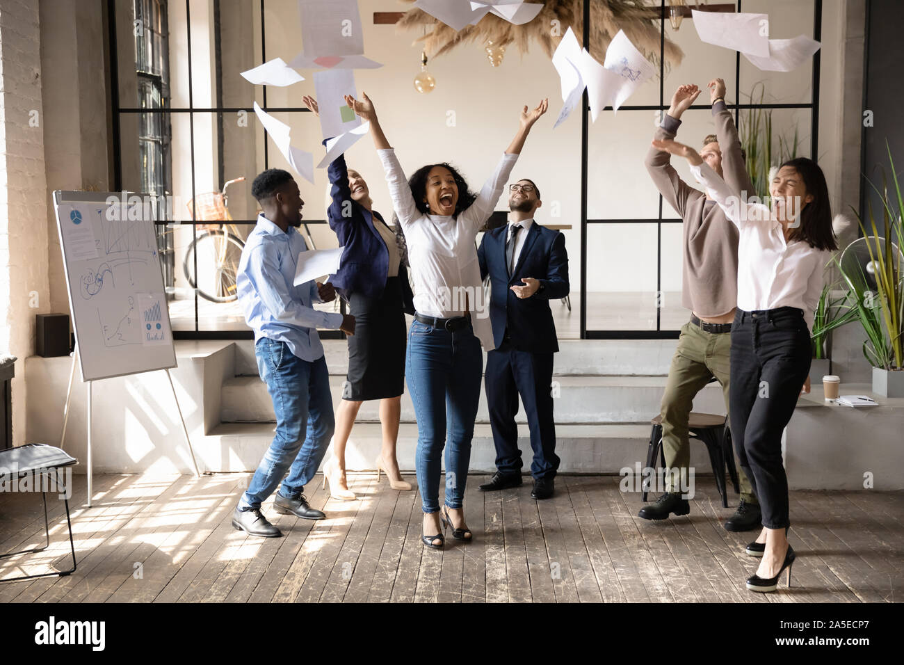 Funny happy multiracial corporate team people dancing toss papers Stock ...