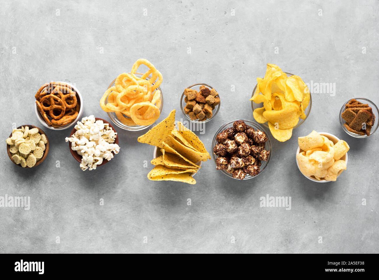 Assortment of Unhealthy Snacks: chips, popcorn, nachos, pretzels, onion ...