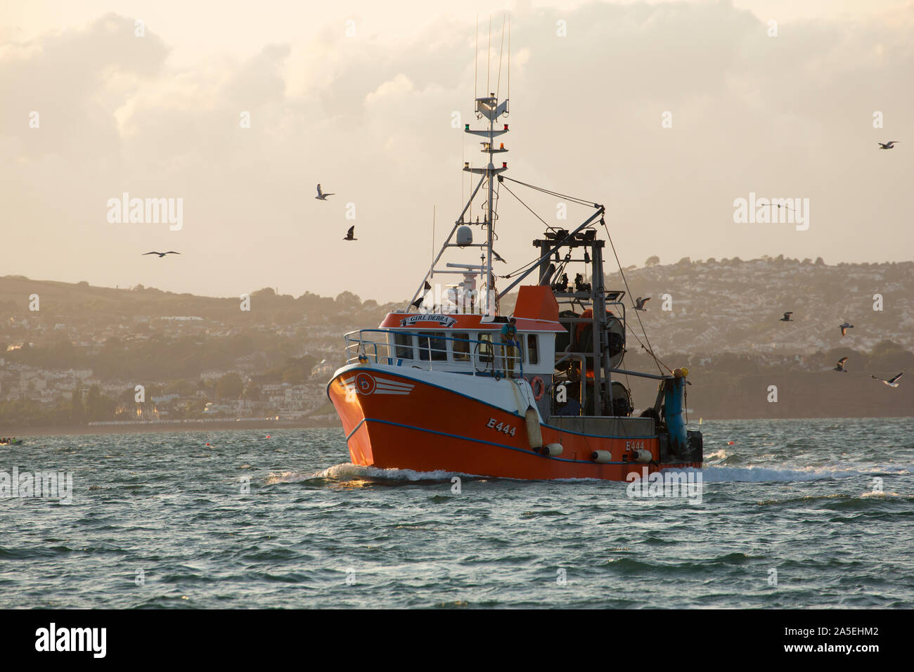A fishing boat entering the outer harbour of Brixham Port. Brixham is ...