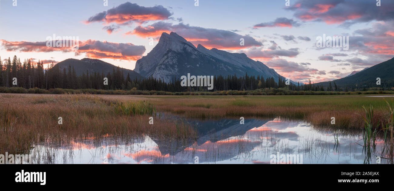 Panorama of Mount Rundle mountain peak with blue sky reflecting in ...