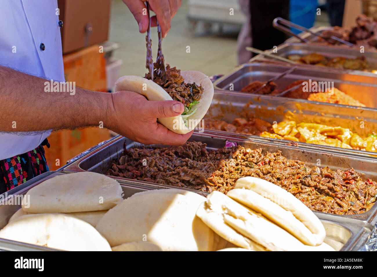 Man hands making gyro into pita Stock Photo - Alamy