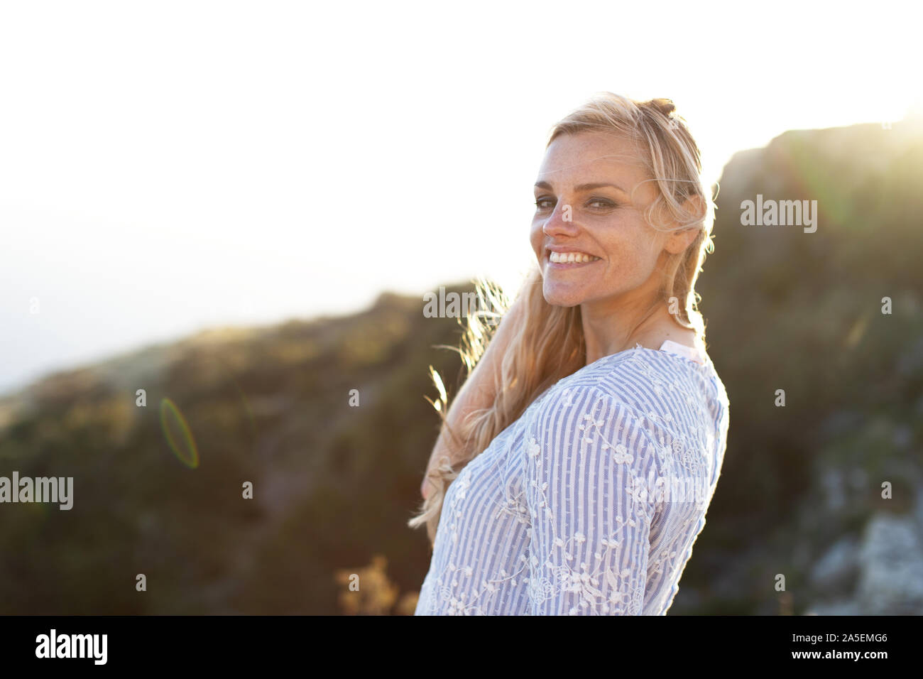 Blonde young natural woman looking back outdoors Stock Photo - Alamy