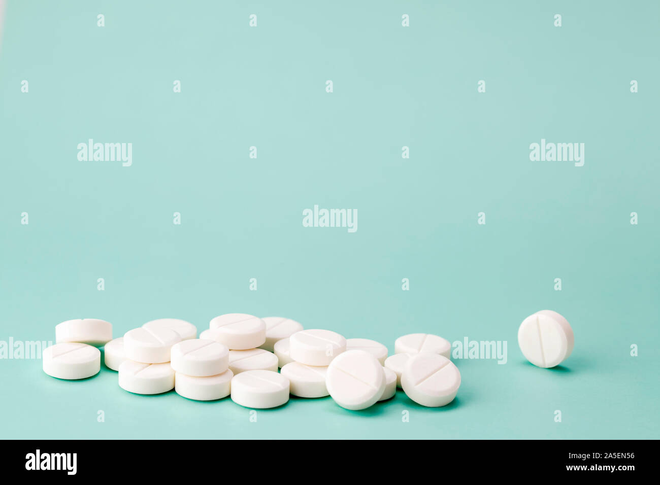 White round tablets scattered on colour background Stock Photo - Alamy