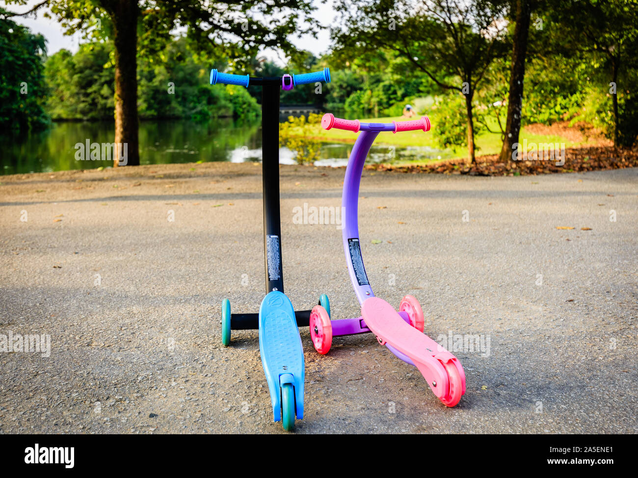 pink and blue color children scooter parked on road Stock Photo - Alamy