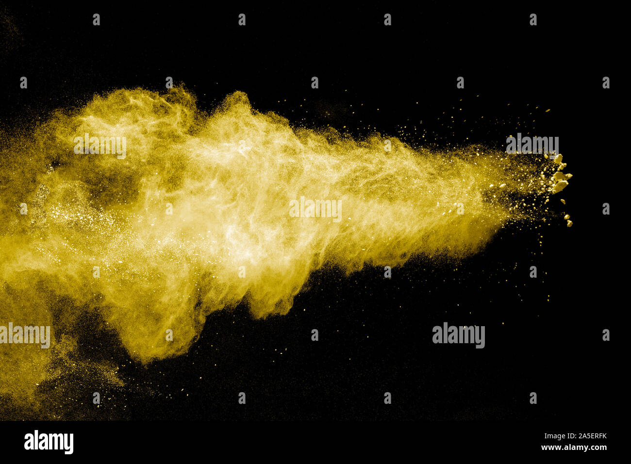 Abstract yellow powder explosion on black background.Freeze motion of ...
