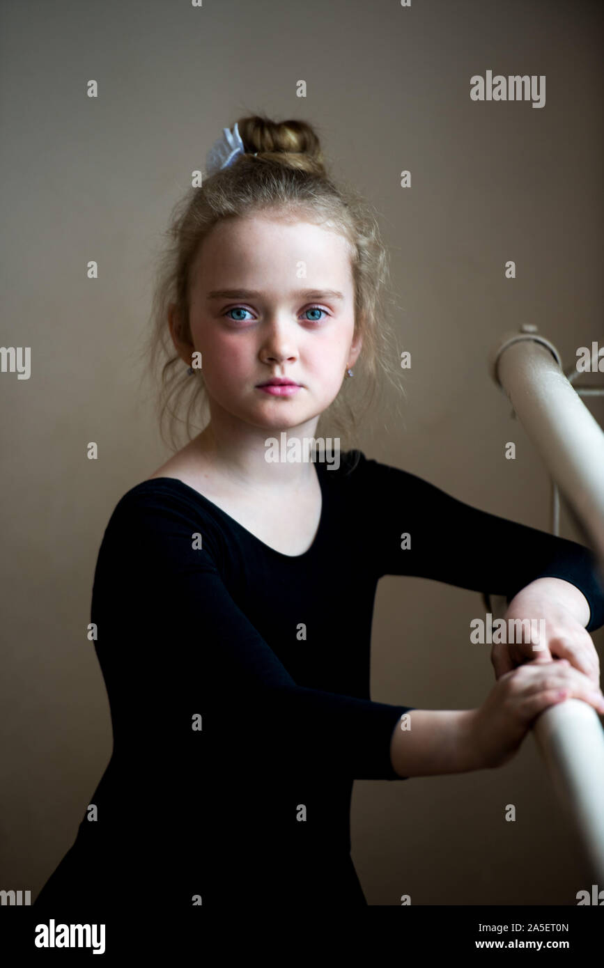 Tired young ballerina. Portrait of a cute little girl in a ballet class ...