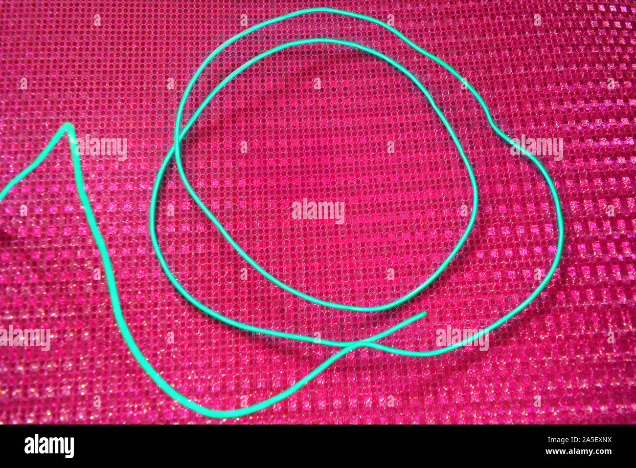 Green glowing wire, cold neon, electroluminescent cord, cable lies on a ...