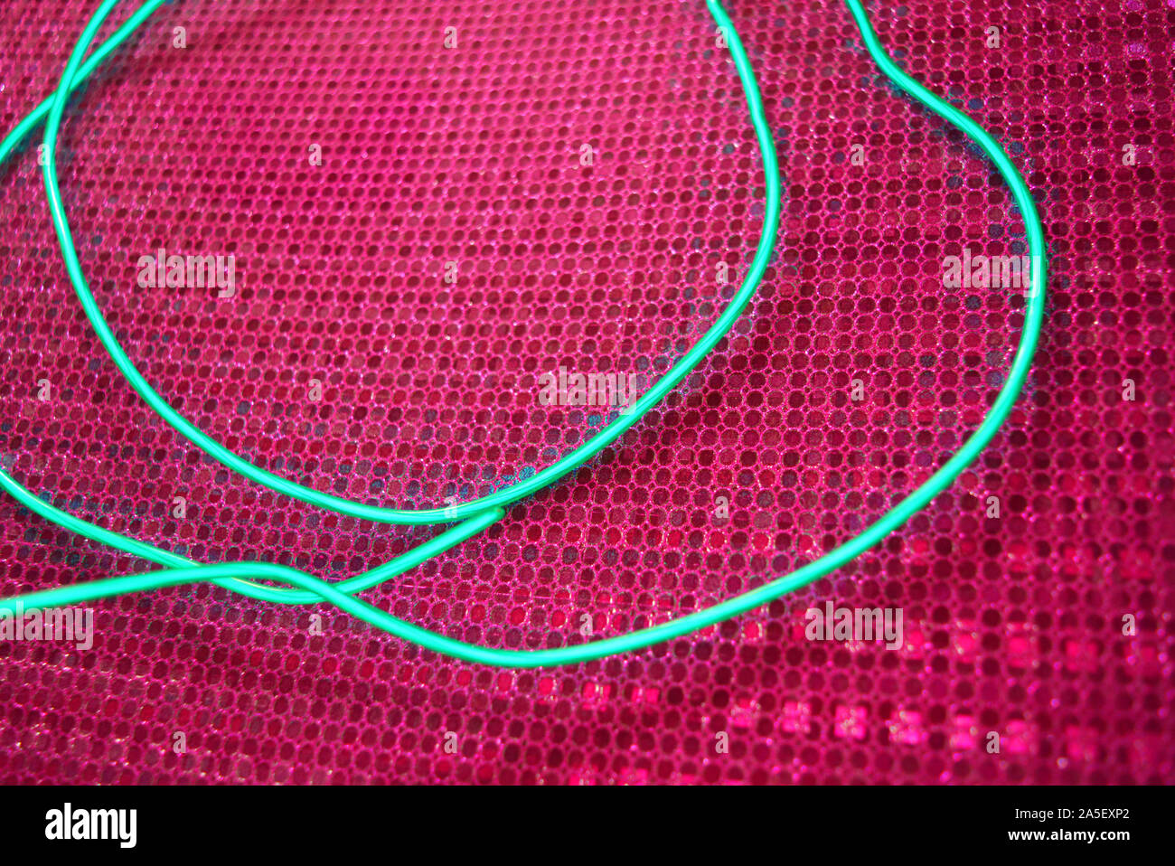 Green glowing wire, cold neon, electroluminescent cord, cable lies on a ...