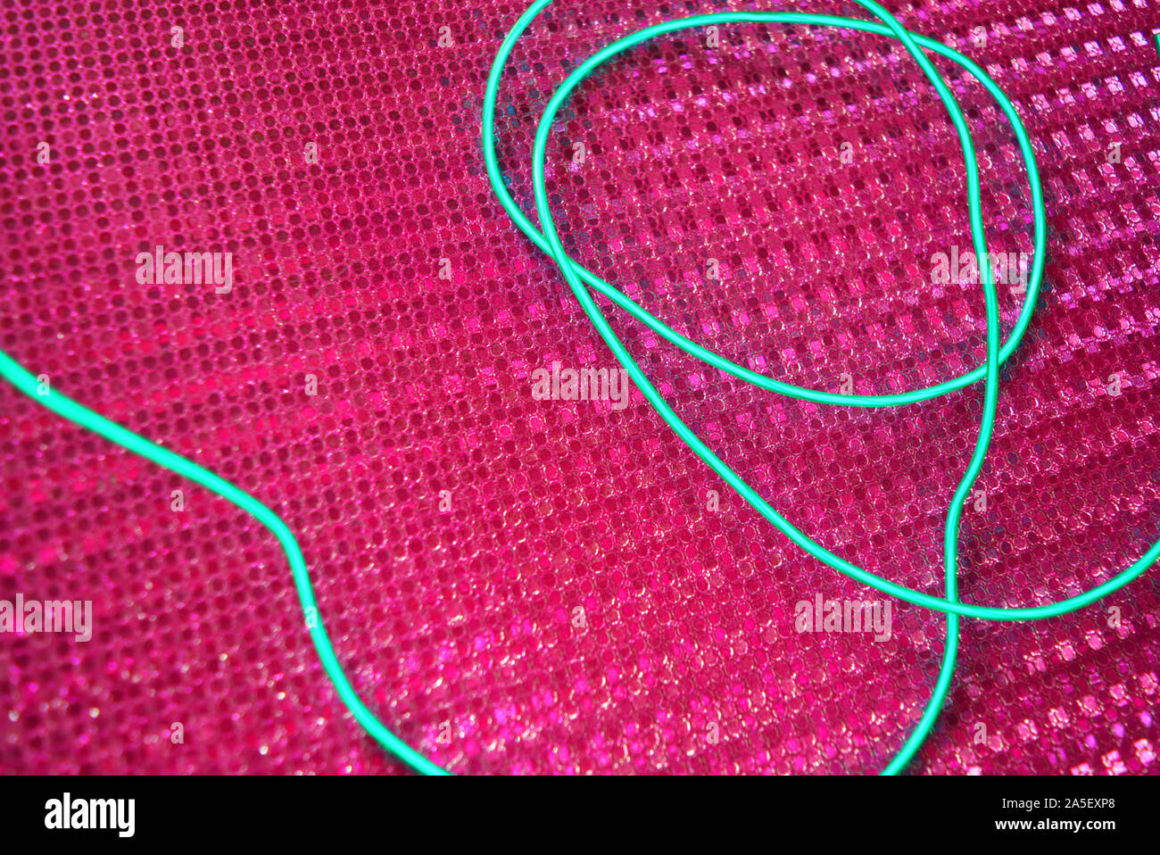 Green glowing wire, cold neon, electroluminescent cord, cable lies on a ...