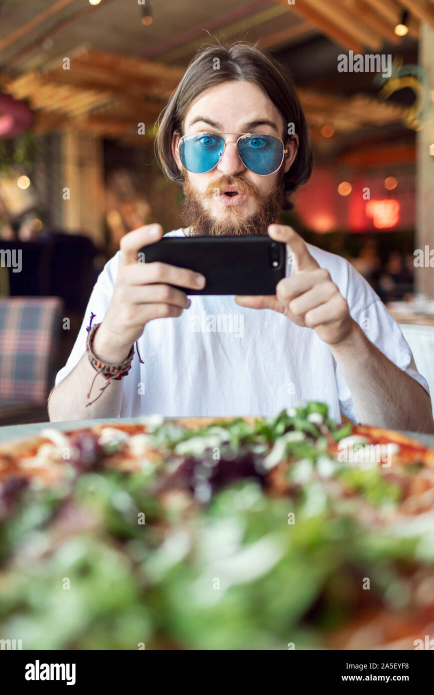 Young surprised male customer can not stop making and sharing the photo ...