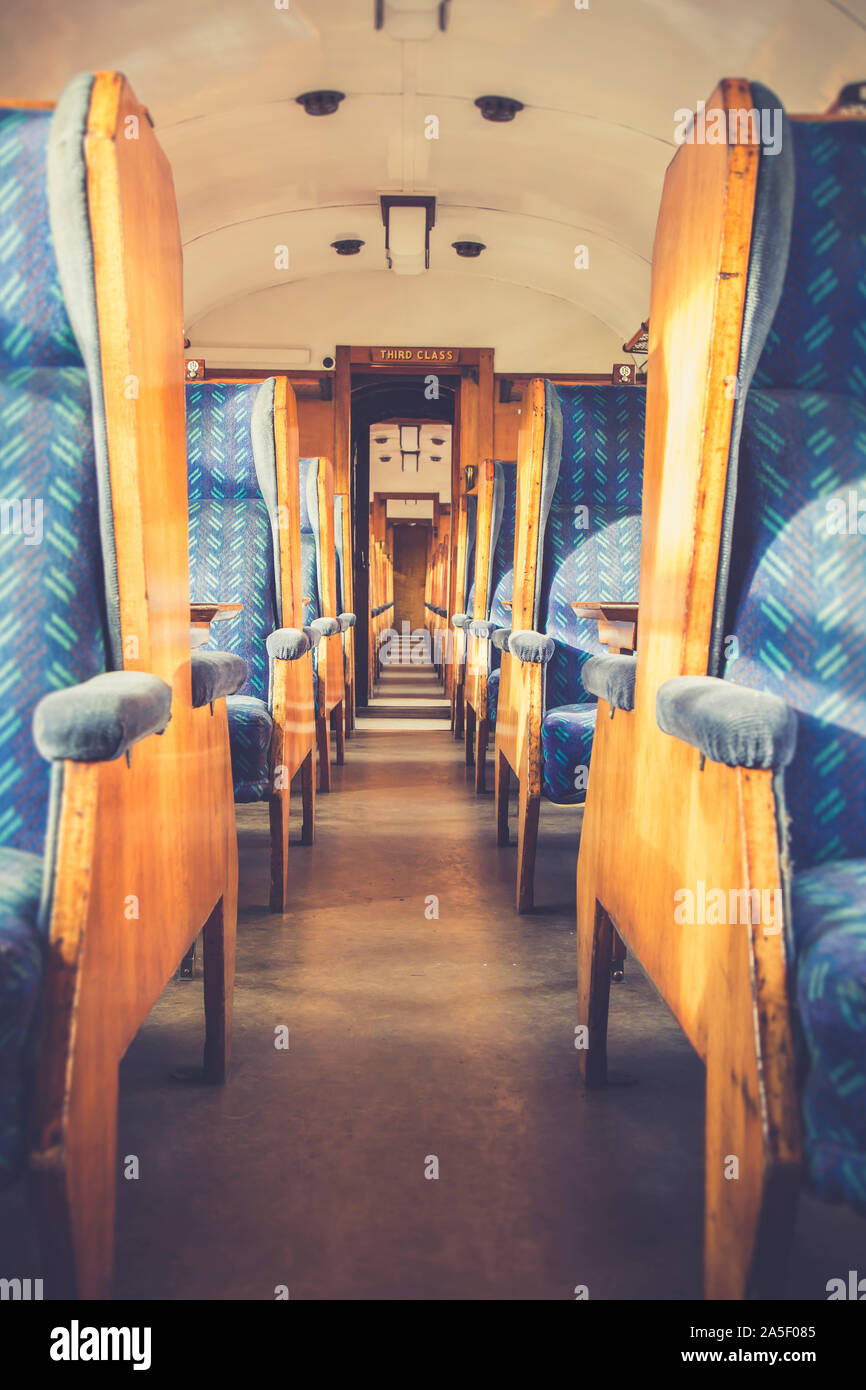 Retro interior view of empty UK vintage railway carriage lit by autumn ...
