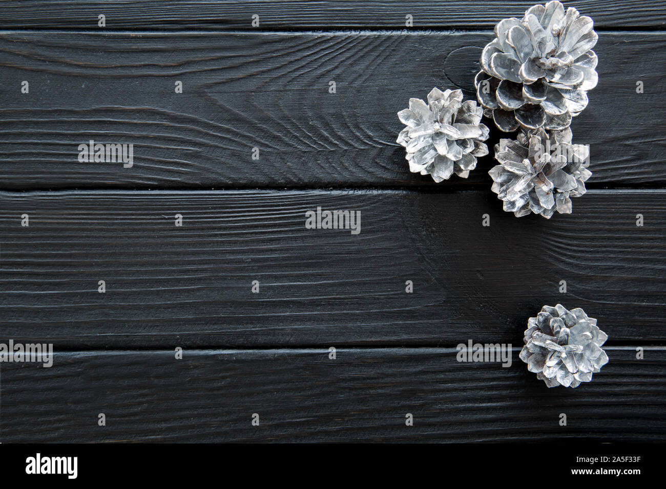 Silver pine cones (fir cones) on black wooden table background. Free ...