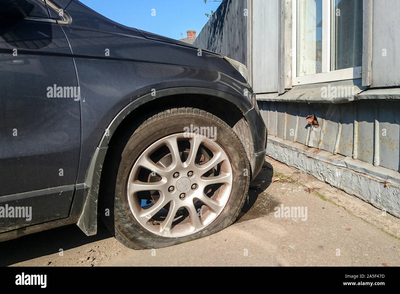 a traffic accident on a city street, a car with a broken and empty tire ...