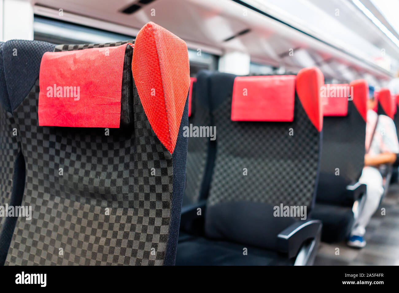 Empty red comfortable chairs seats row closeup in aisle in subway train ...