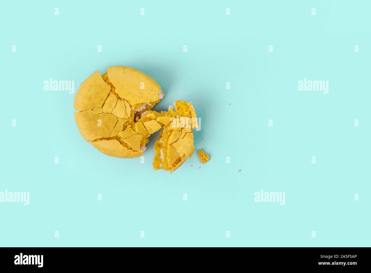 Crushed yellow macaroon on pastel blue background with copy space Stock ...