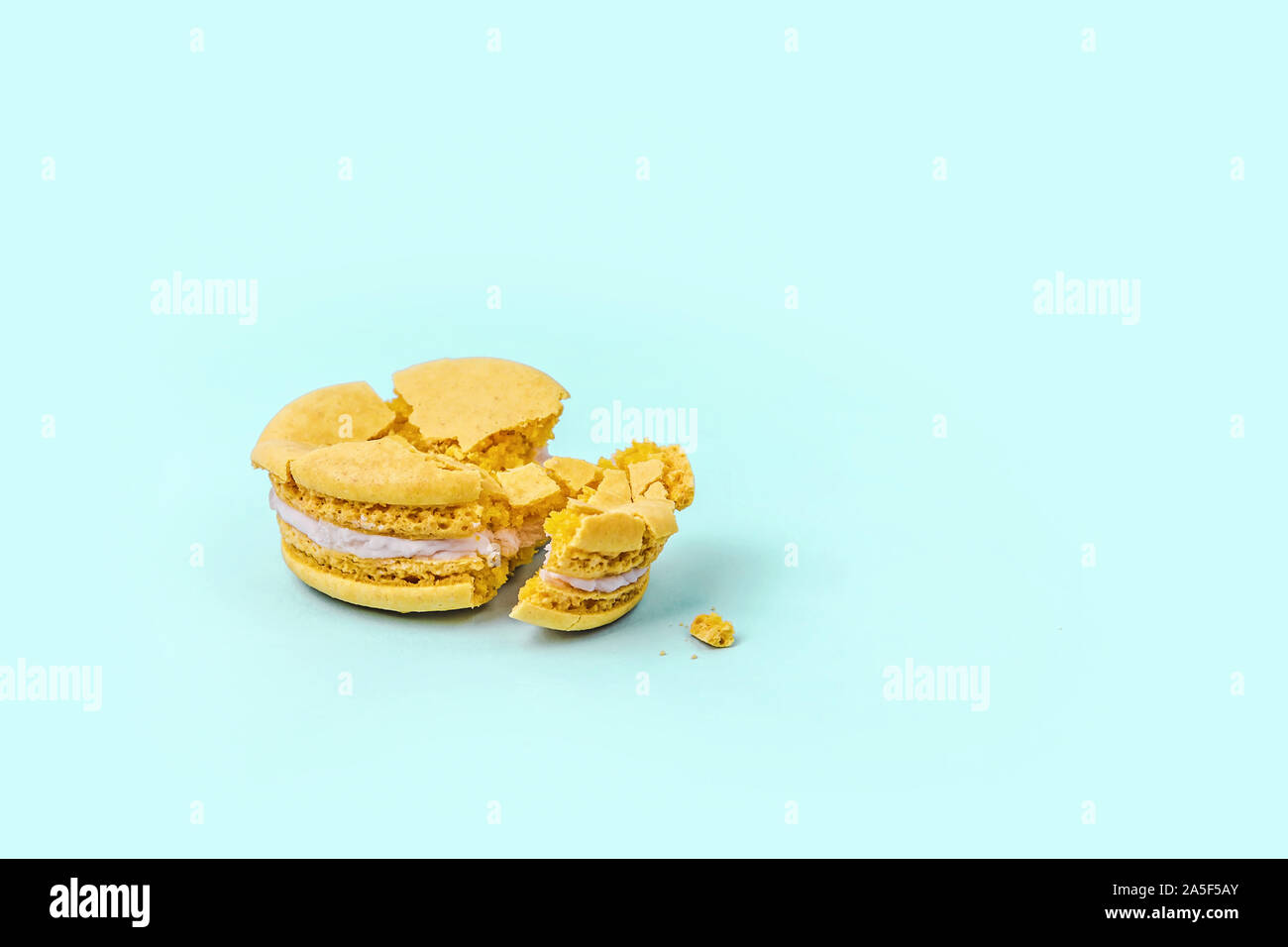 Crushed yellow macaroon on pastel blue background with copy space Stock ...