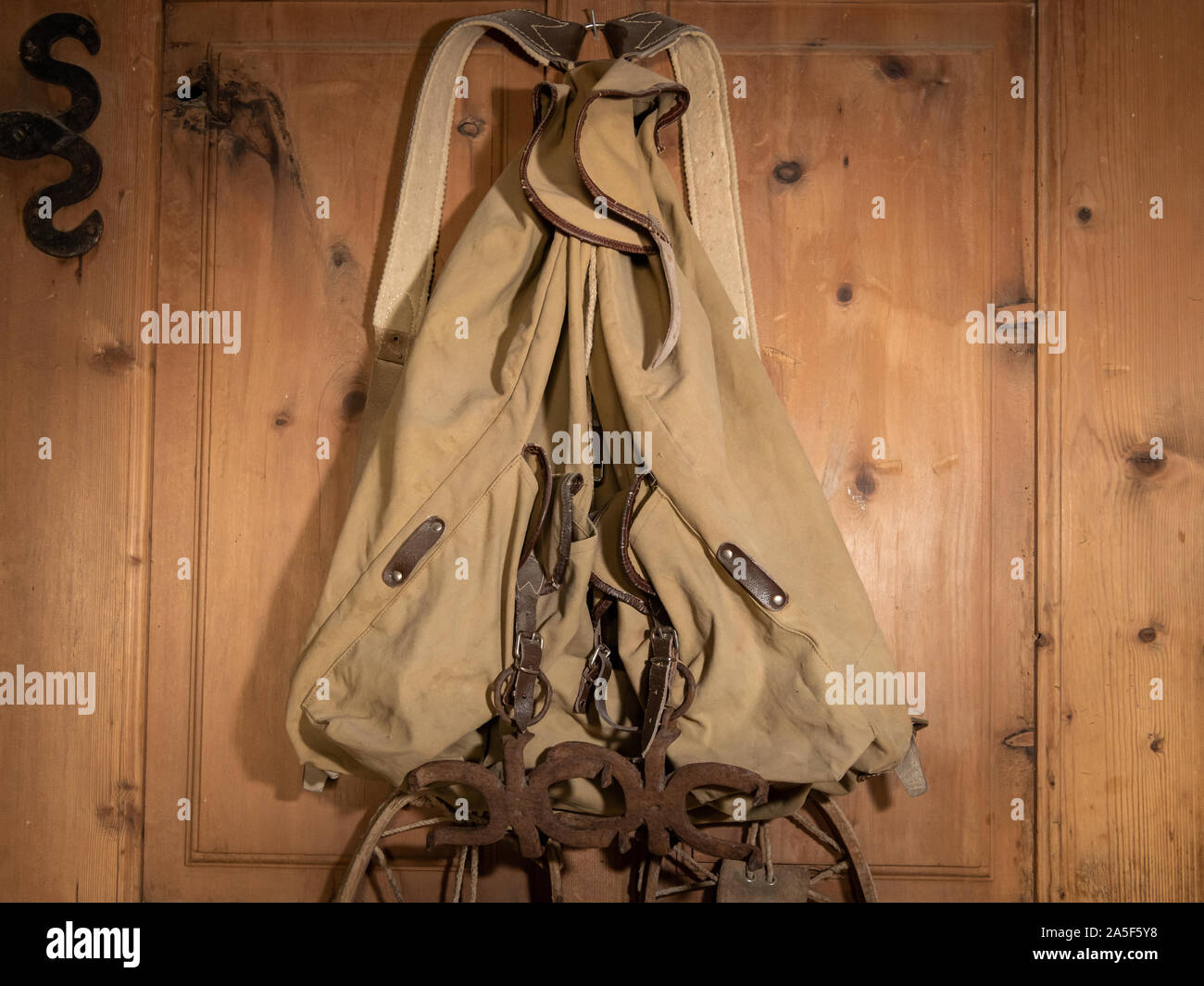 Closeup of a very old backpack hanging on a wooden wall Stock Photo - Alamy