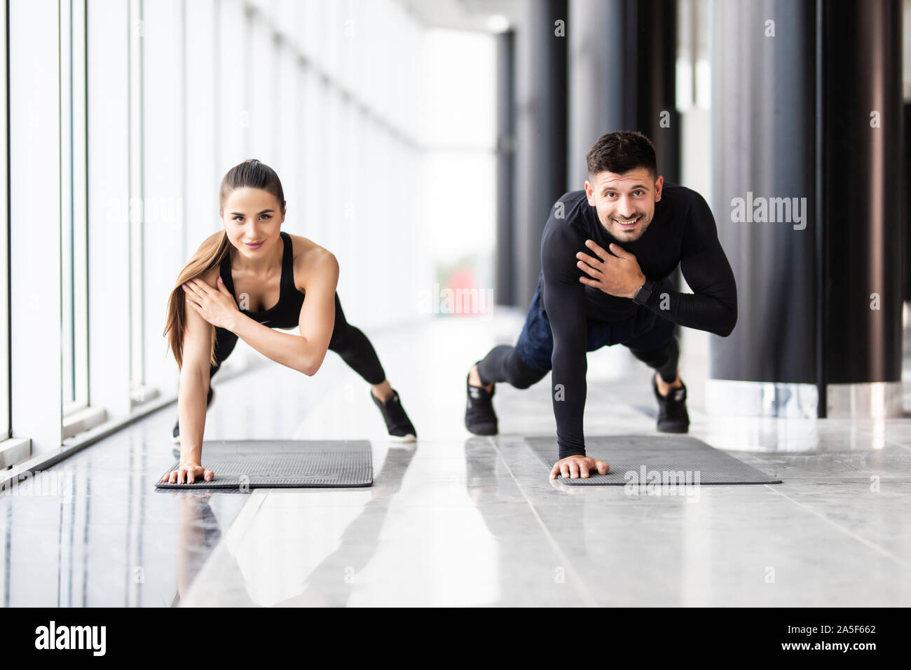 Couple doing plank with one hand at the gym Stock Photo - Alamy