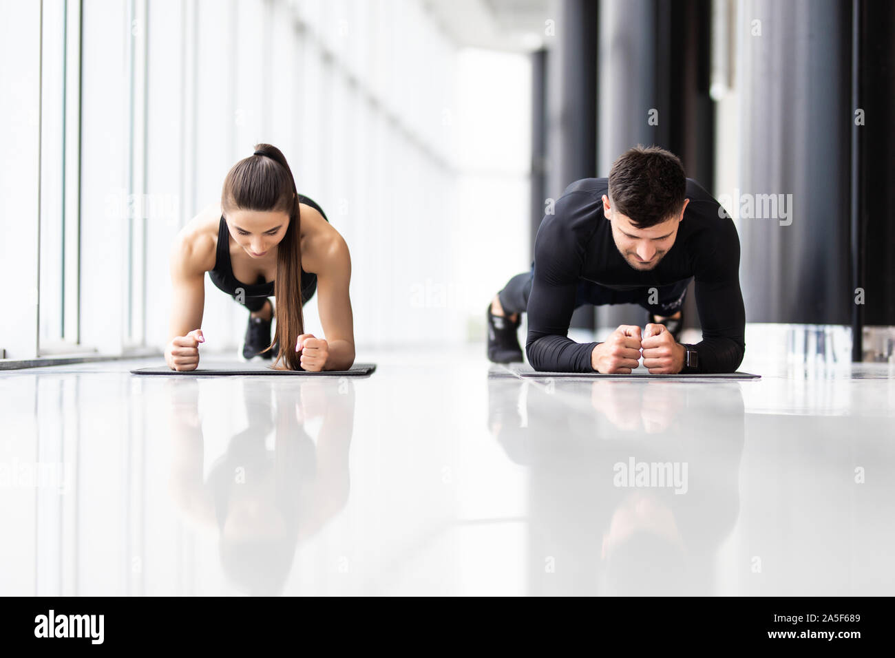 Portrait of a muscular couple doing planking exercises Stock Photo - Alamy