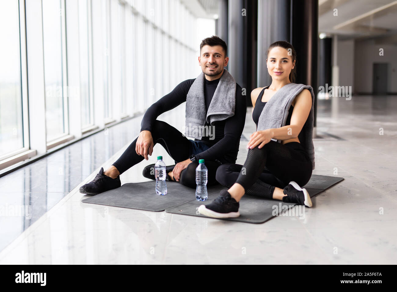 Young healthy couple relaxing after workout in the gym with happy ...
