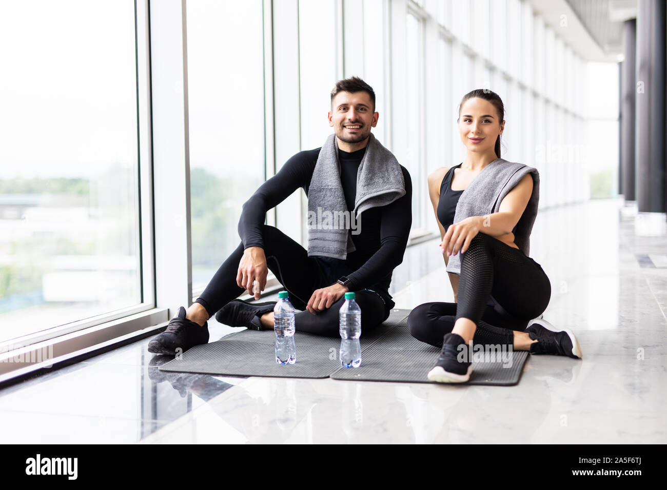 Young healthy couple relaxing after workout in the gym with happy ...