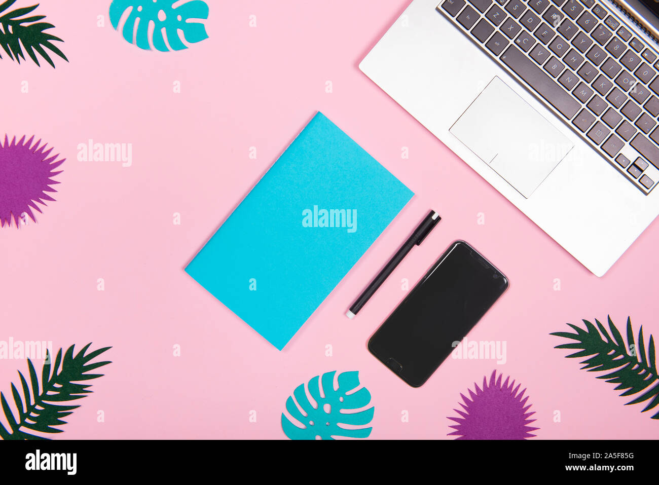 Office workplace with laptop computer and daily planner, with tropical ...