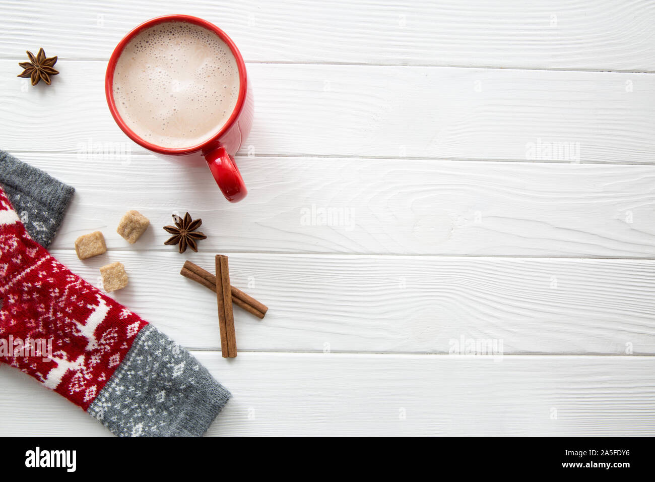 Red Christmas socks with deer and ornament on white wooden background ...