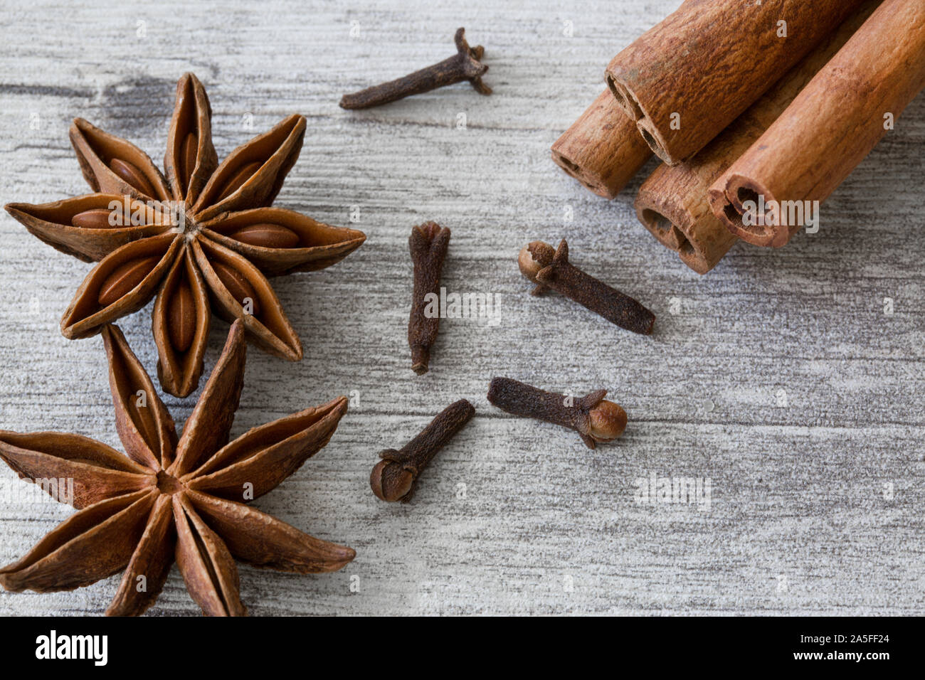 Anise stars, cloves and cinnamon sticks on grey wooden background ...