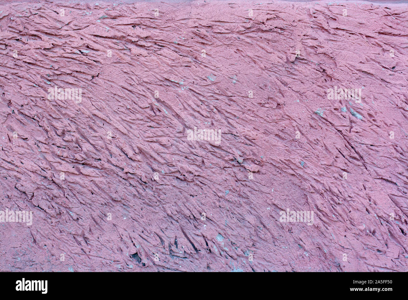 Pink painted mortar texture on an old stone wall. Dented stripes and ...