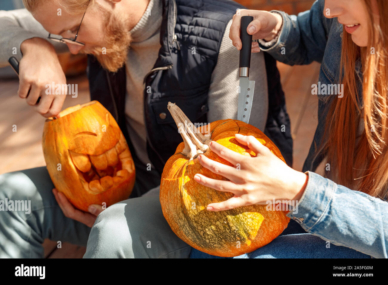 Halloween Preparaton Concept. Young couple outdoors making jack-o ...