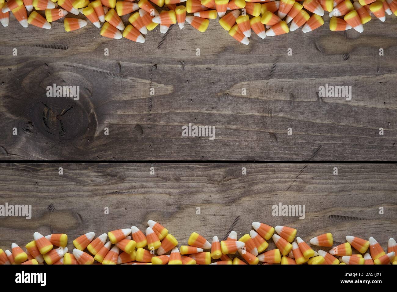 Overhead shot of candy corns on the bottom and top on a wooden surface ...