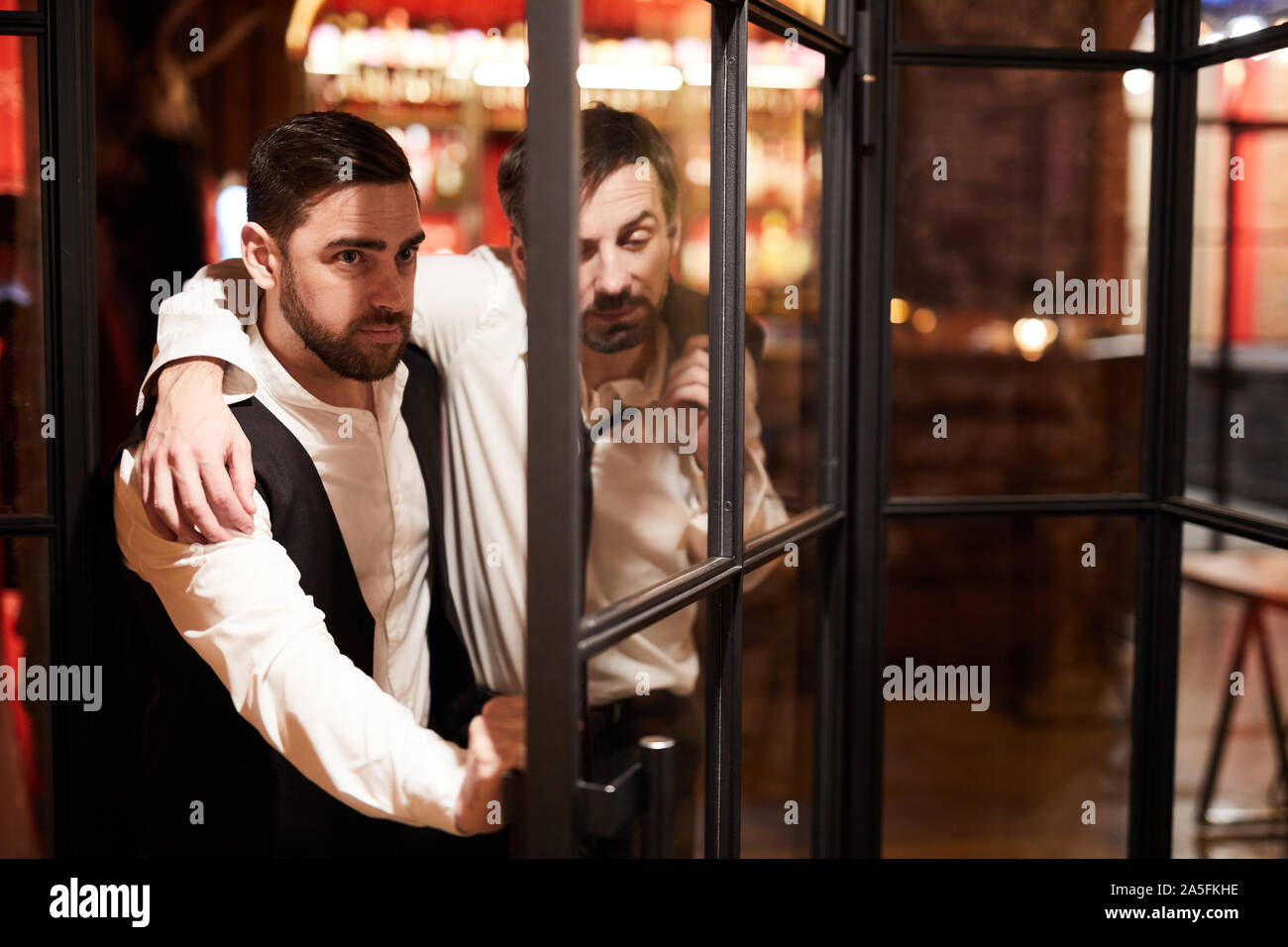 Two men carrying drunk man hi-res stock photography and images - Alamy