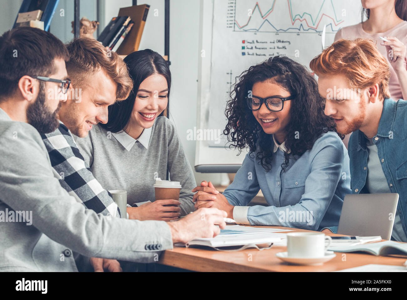 Startupers working together at office sitting designing project plan ...