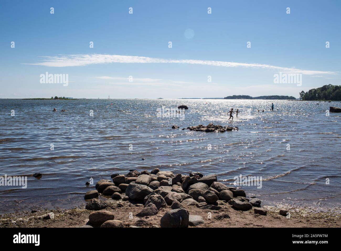 A beautiful beach and clear blue sky with people having fun and ...