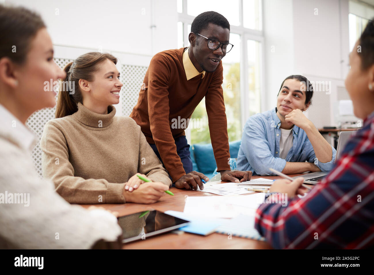Large group of students working together on team project while studying ...