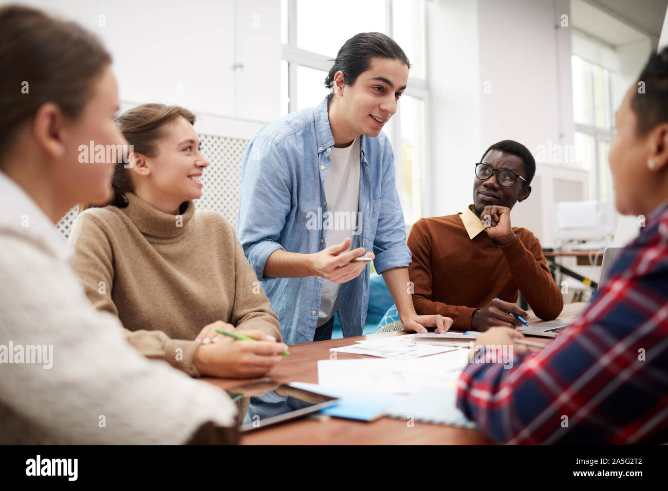Large group of students working together on team project while studying ...