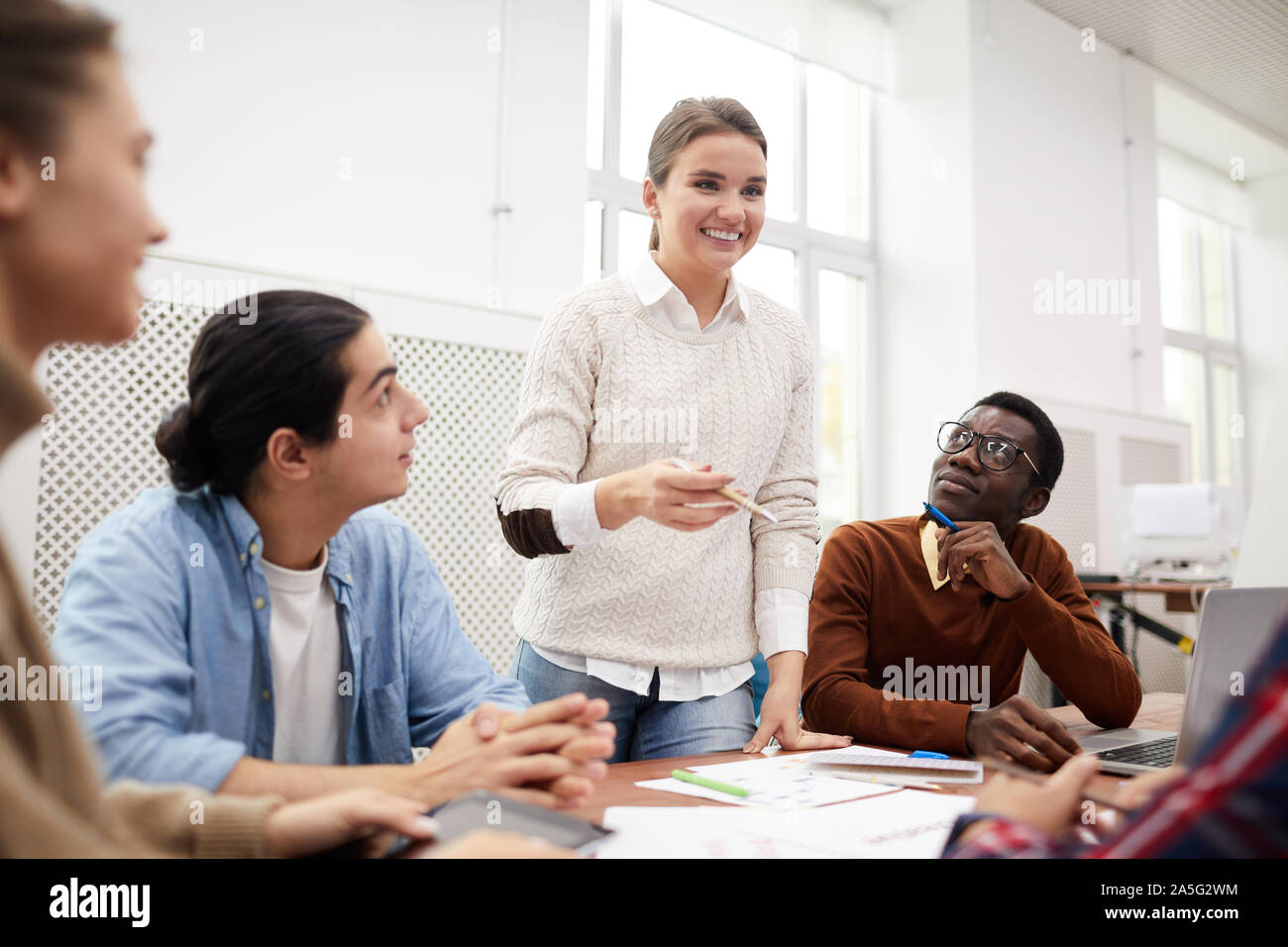 Multi-ethnic group of students working together on team project while ...