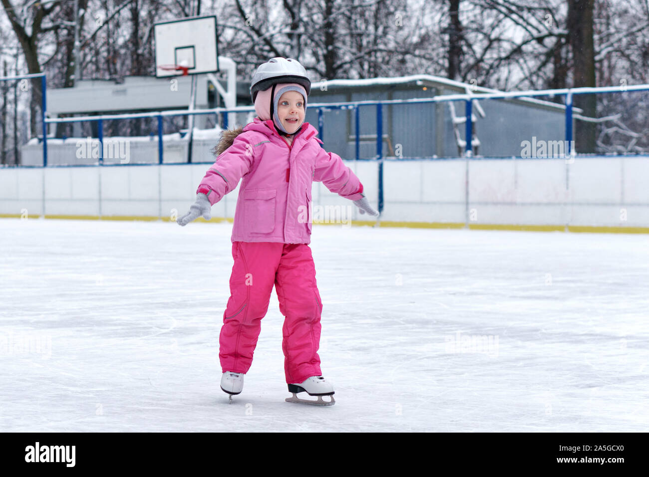 Beautiful girl having fun in winter park, balancing while skating at ...