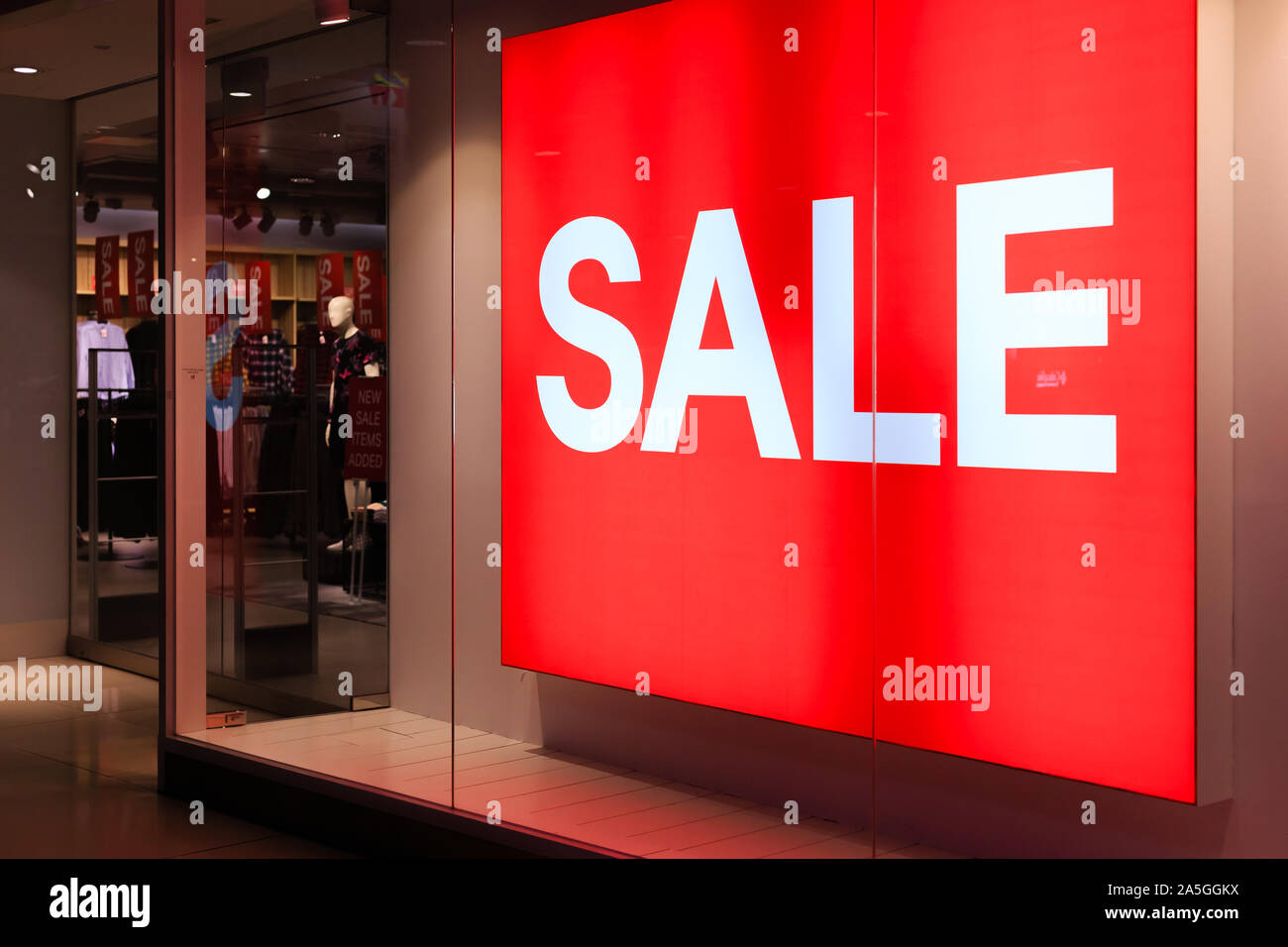 Window display with red sale board in night Stock Photo - Alamy