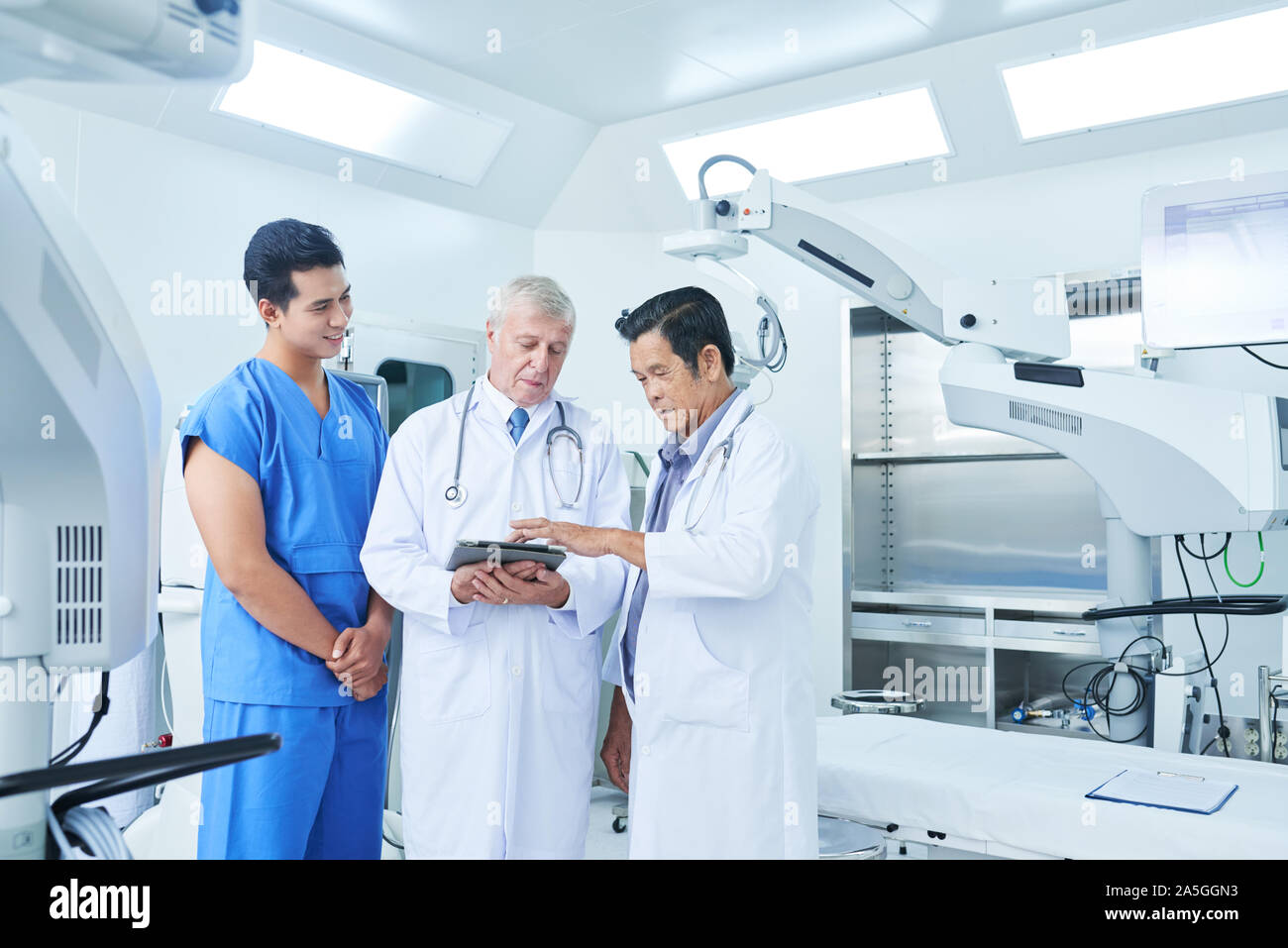 Physicians and surgeon meeting in operating theater to discuss medical ...