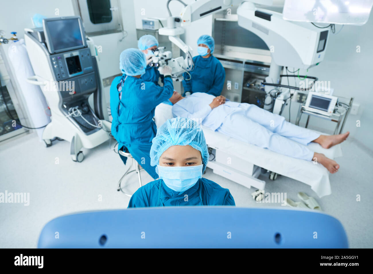 Vietnamese surgical assistant using computer to manipulate equipment ...