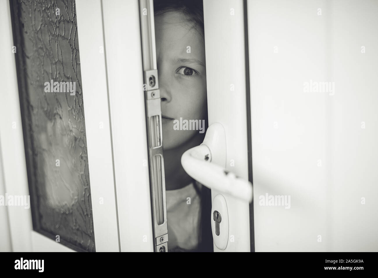 Scared girl kid in opened door. Safety abstract concept Stock Photo - Alamy