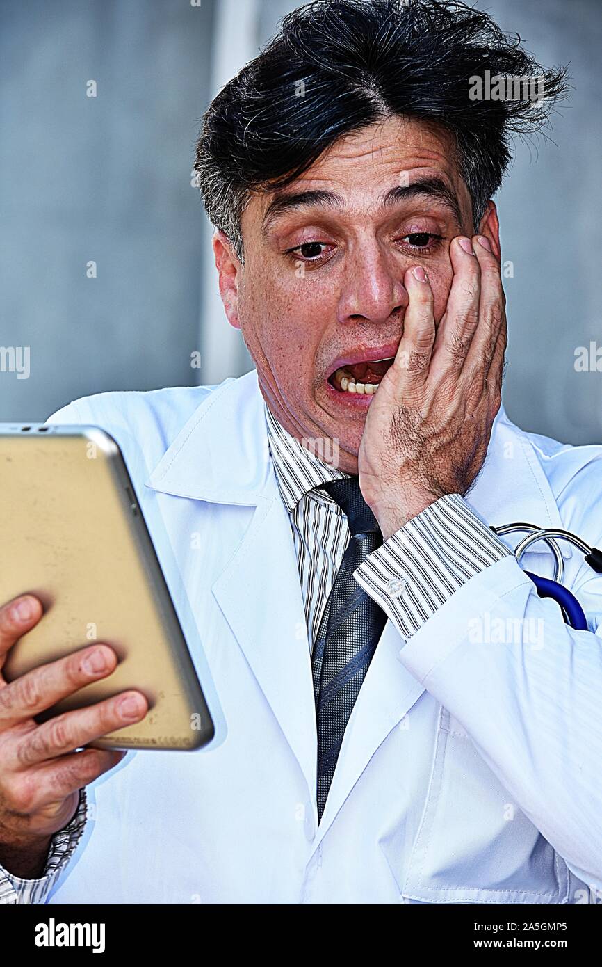 Stressed Male Doctor With Tablet Stock Photo - Alamy