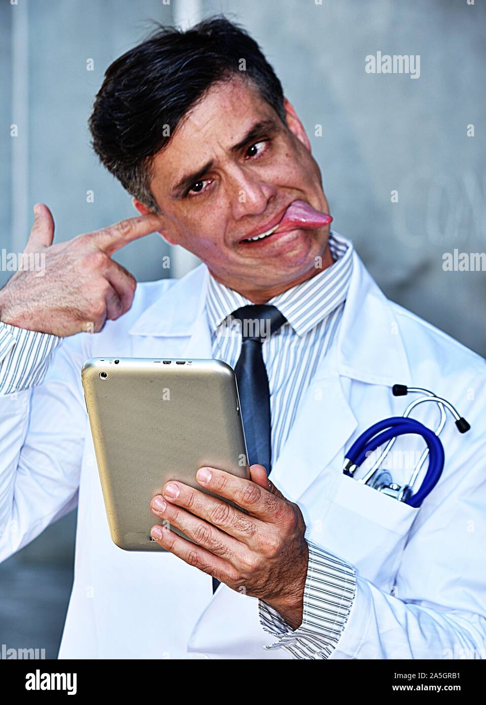 An Insane Male Doctor With Tablet Stock Photo - Alamy