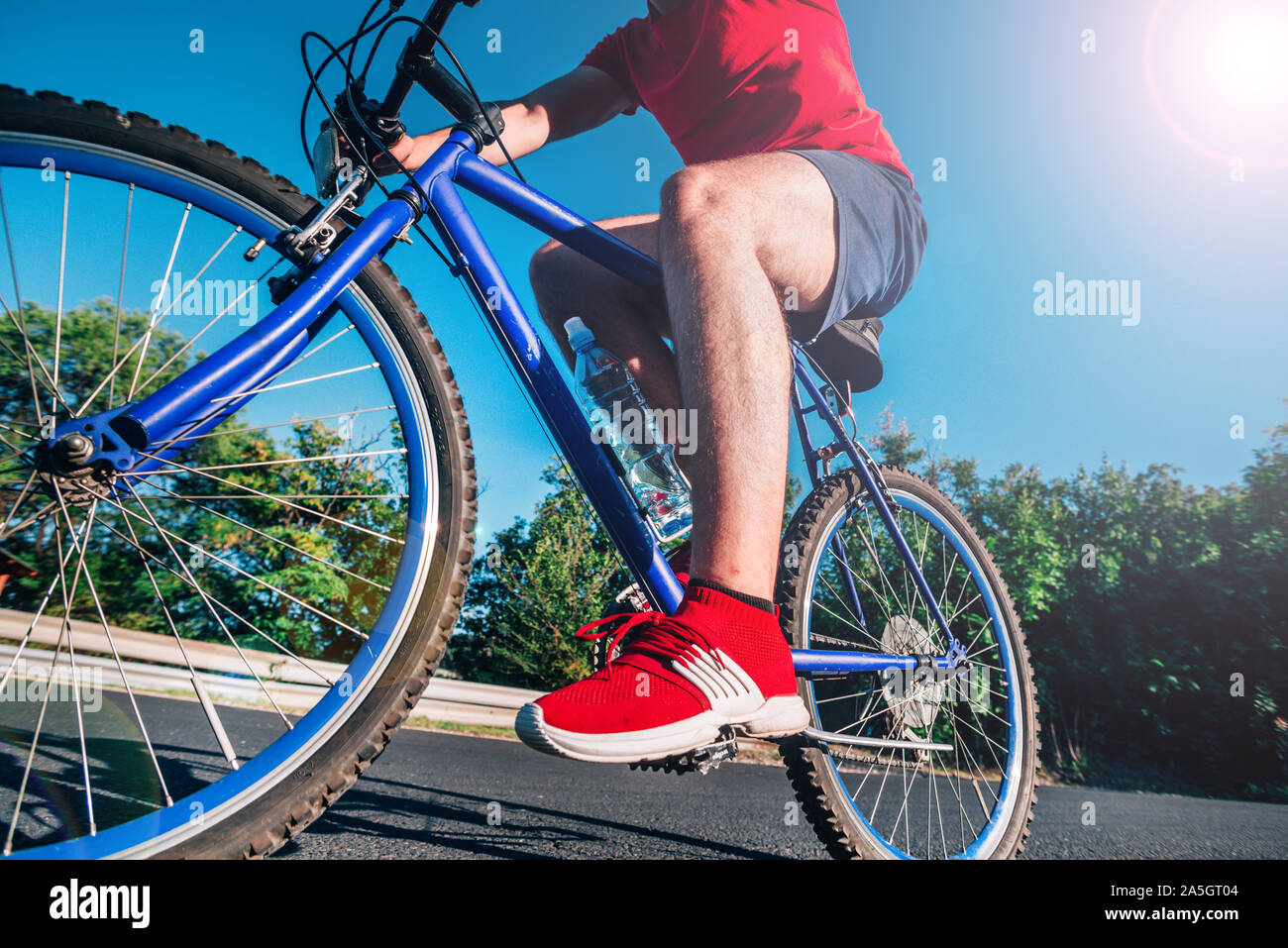 Fit male biker cyclist riding his bike cycle on an asphalt road at ...
